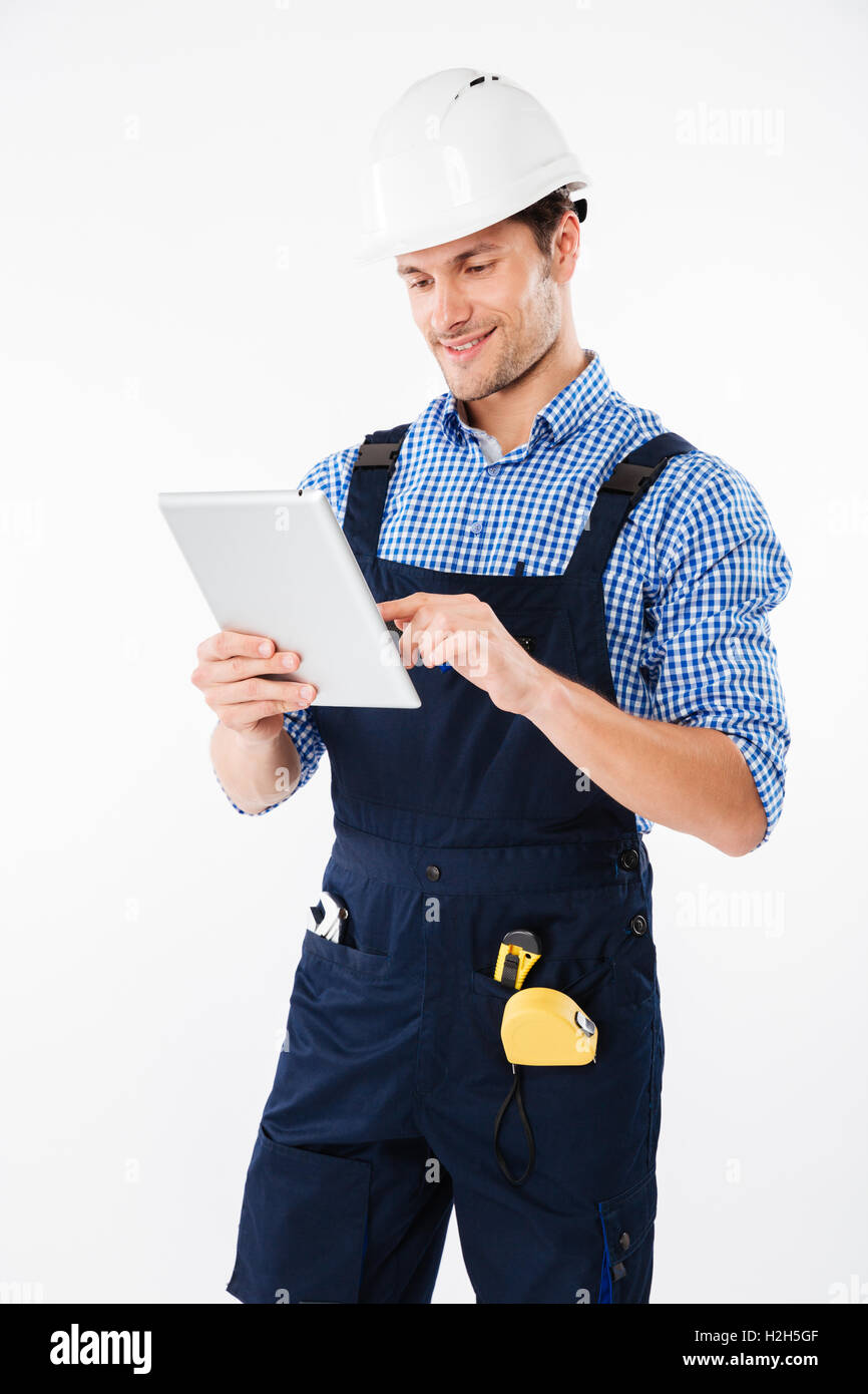 Happy male builder using pc tablet isolated on a white background Stock ...