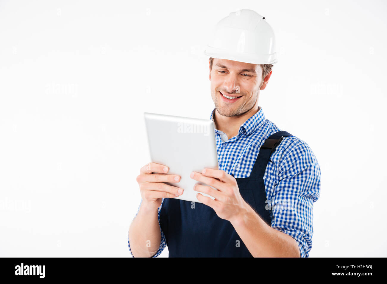 Happy smiling male builder using pc tablet isolated on a white ...
