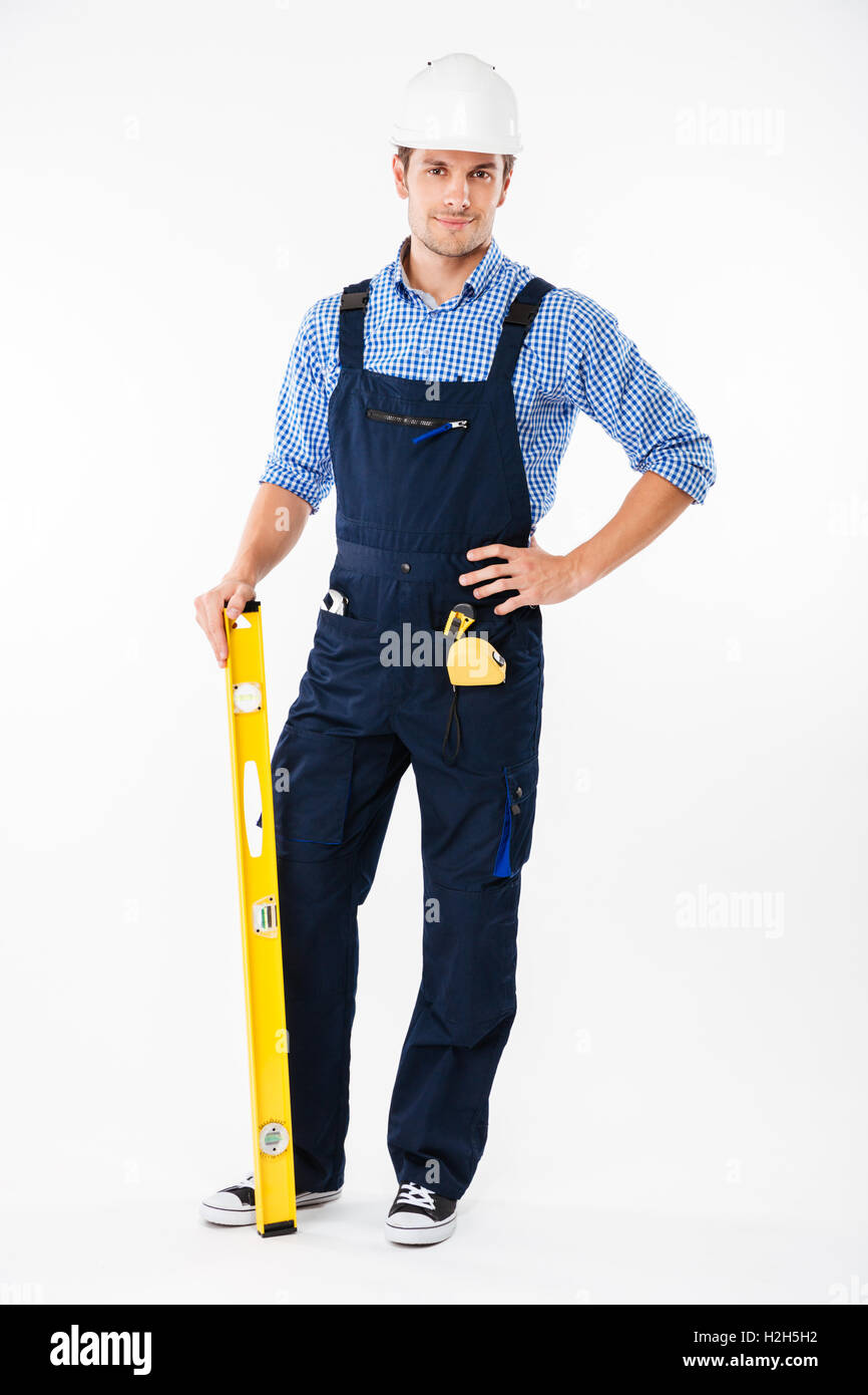 Full length portrait of a smiling male builder standing isolated on a ...
