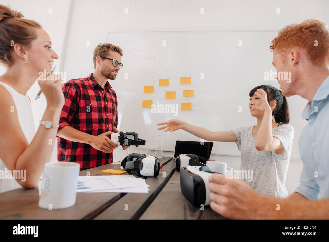 Shot of group of diverse business people discussing virtual reality ...