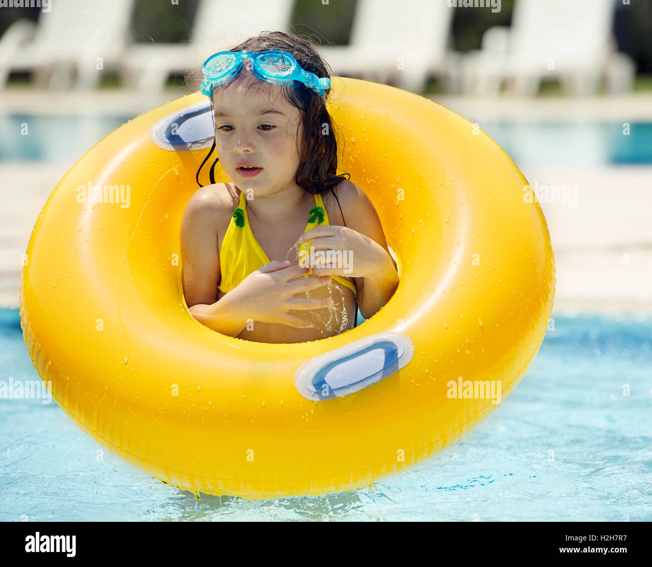 Little girl with inner tube in swimming pool Stock Photo - Alamy