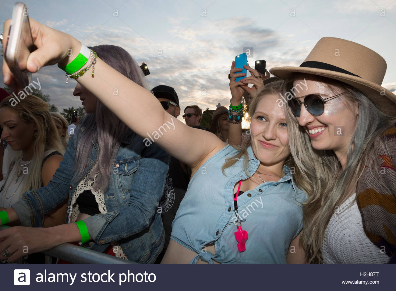 Young women taking selfie in crowd at summer music festival Stock Photo ...