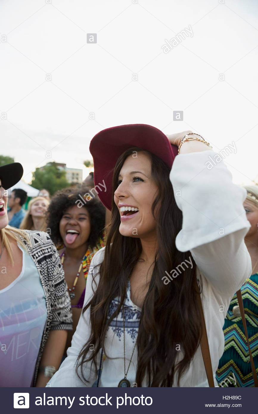 Smiling young woman in crowd at summer music festival Stock Photo - Alamy