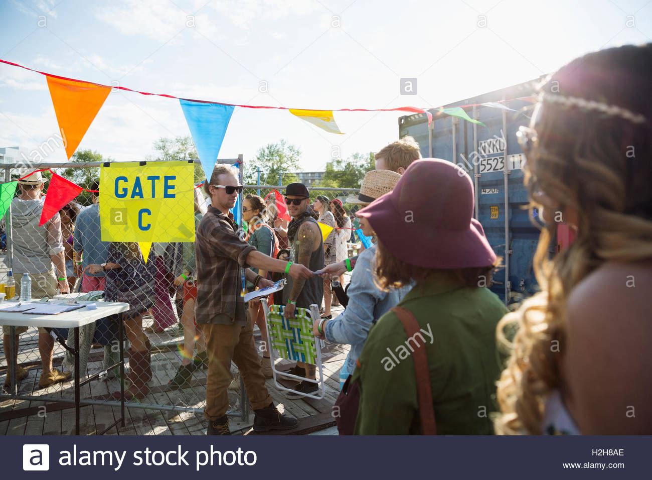 Young crowd waiting in queue at summer music festival entrance Stock ...