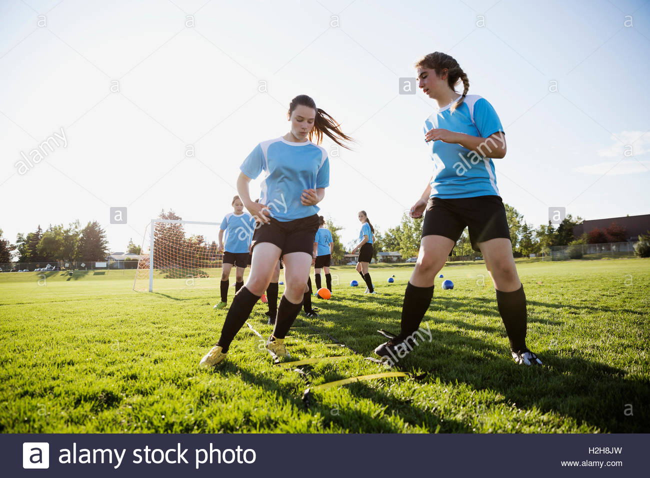 Middle school girl soccer team running drills at practice on sunny ...