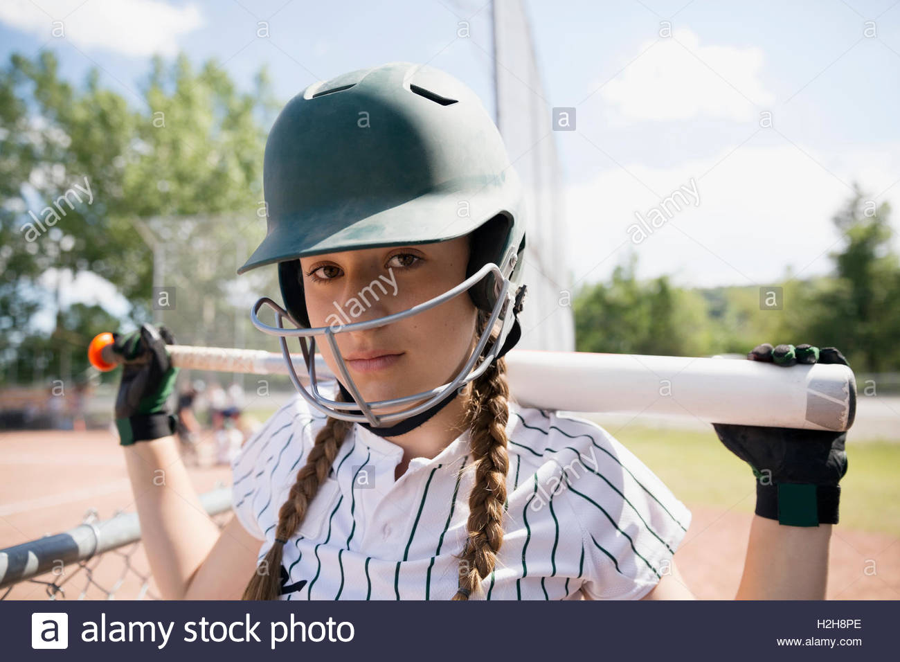Portrait serious middle school girl softball player wearing batting ...