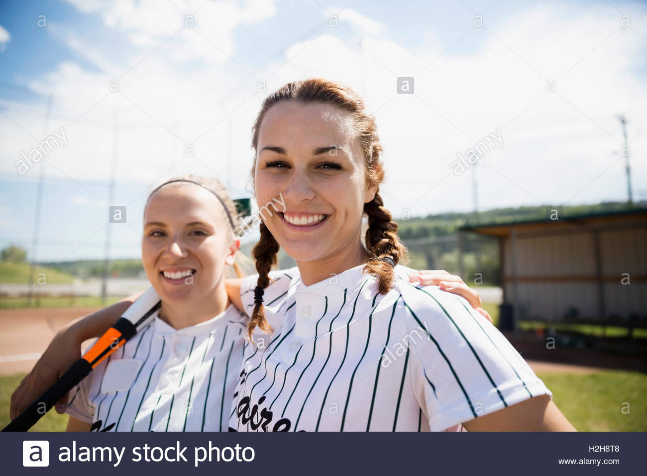 Portrait smiling middle school girl softball players hugging Stock ...