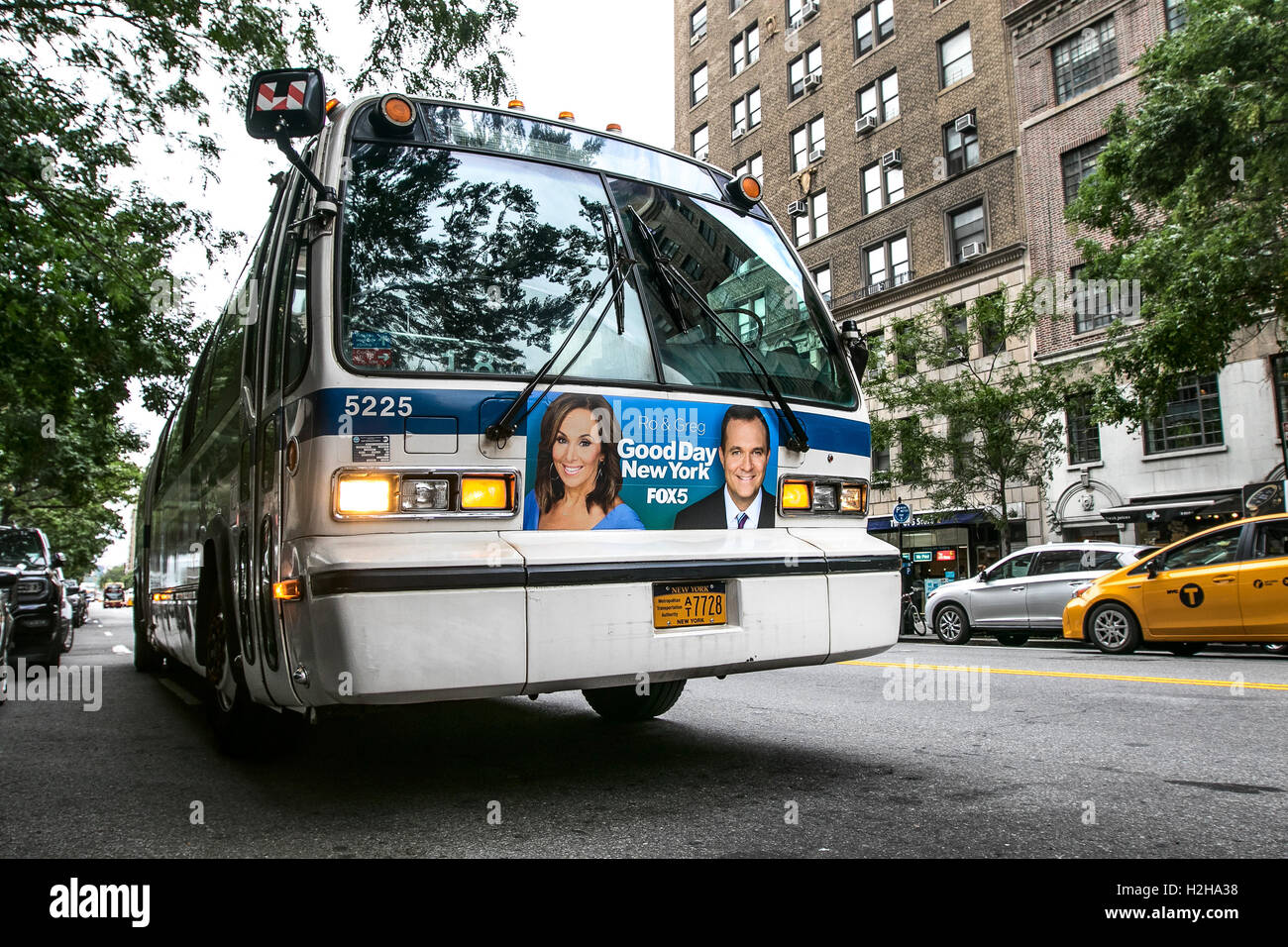 An MTA bus stands idle with lights flashing in the street in Manhattan ...