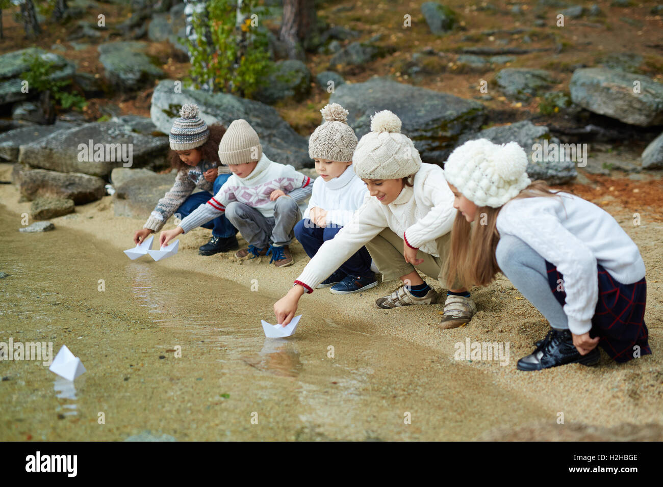 Adorable kids playing with paper ships Stock Photo - Alamy