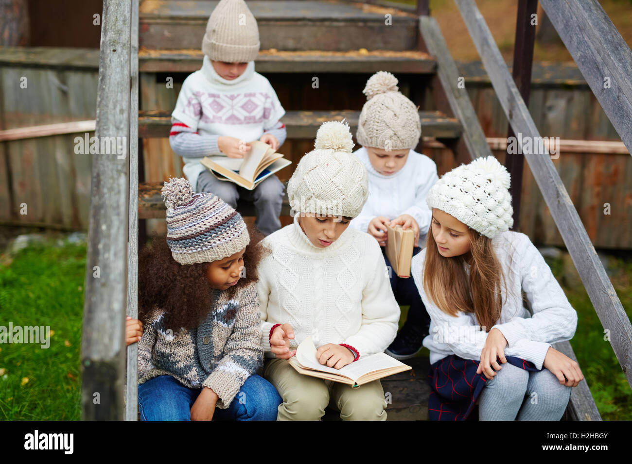 Group of clever kids reading books outdoors Stock Photo - Alamy