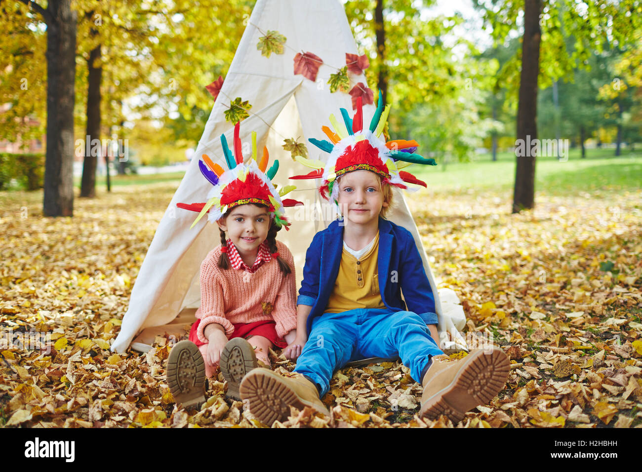 Two kids playing Indians in park at leisure Stock Photo - Alamy