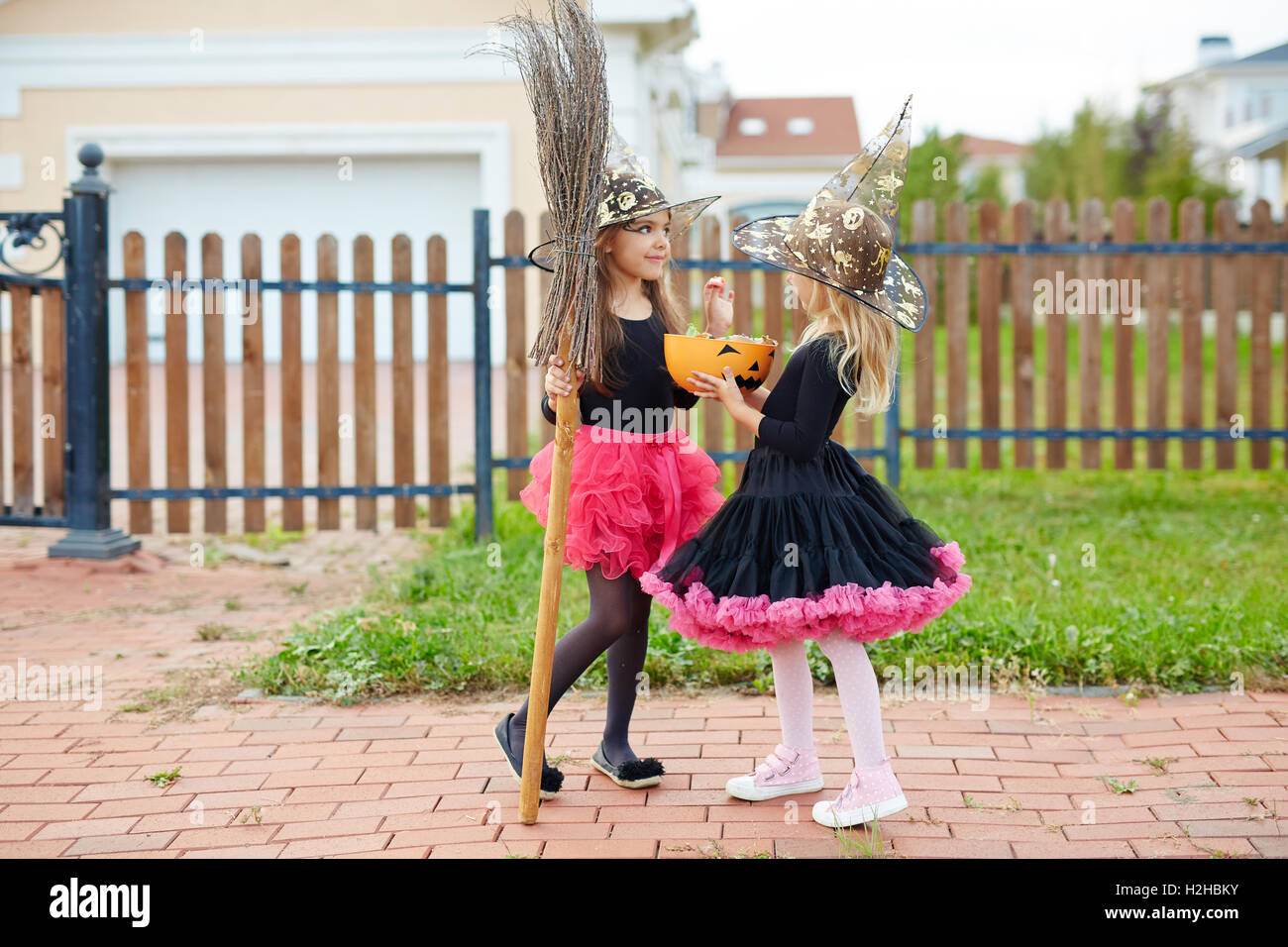 Halloween girl sharing treats with her friend Stock Photo - Alamy