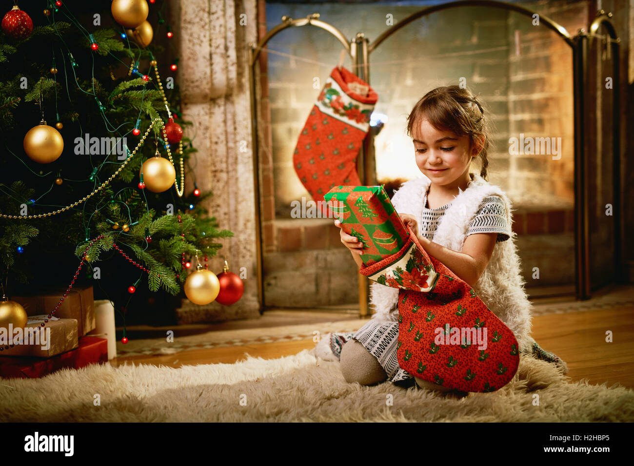 Little girl putting xmas surprise into gift sock Stock Photo - Alamy