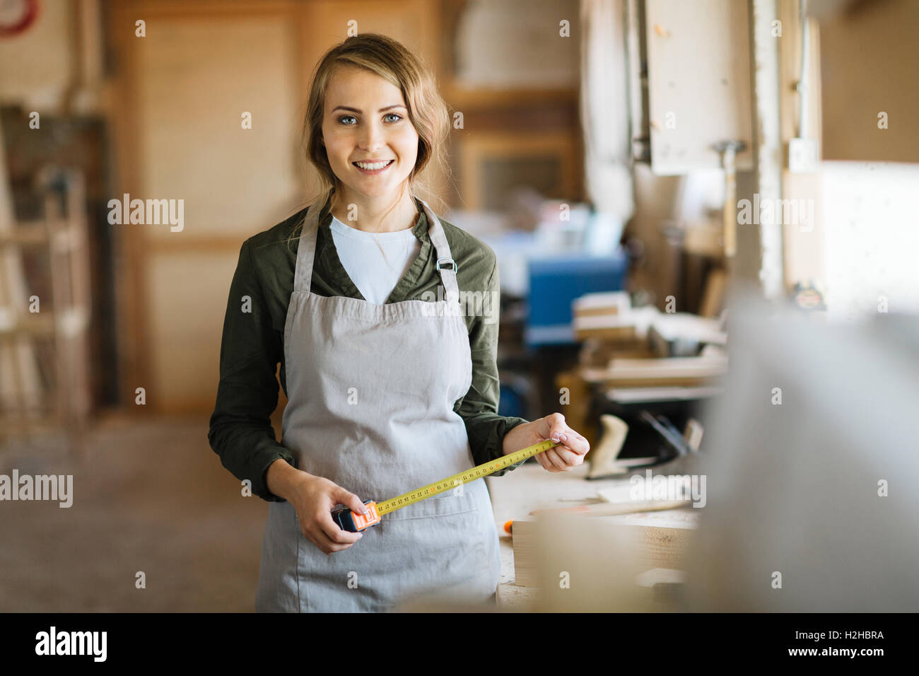 Happy young female in uniform of carpenter looking at camera Stock ...
