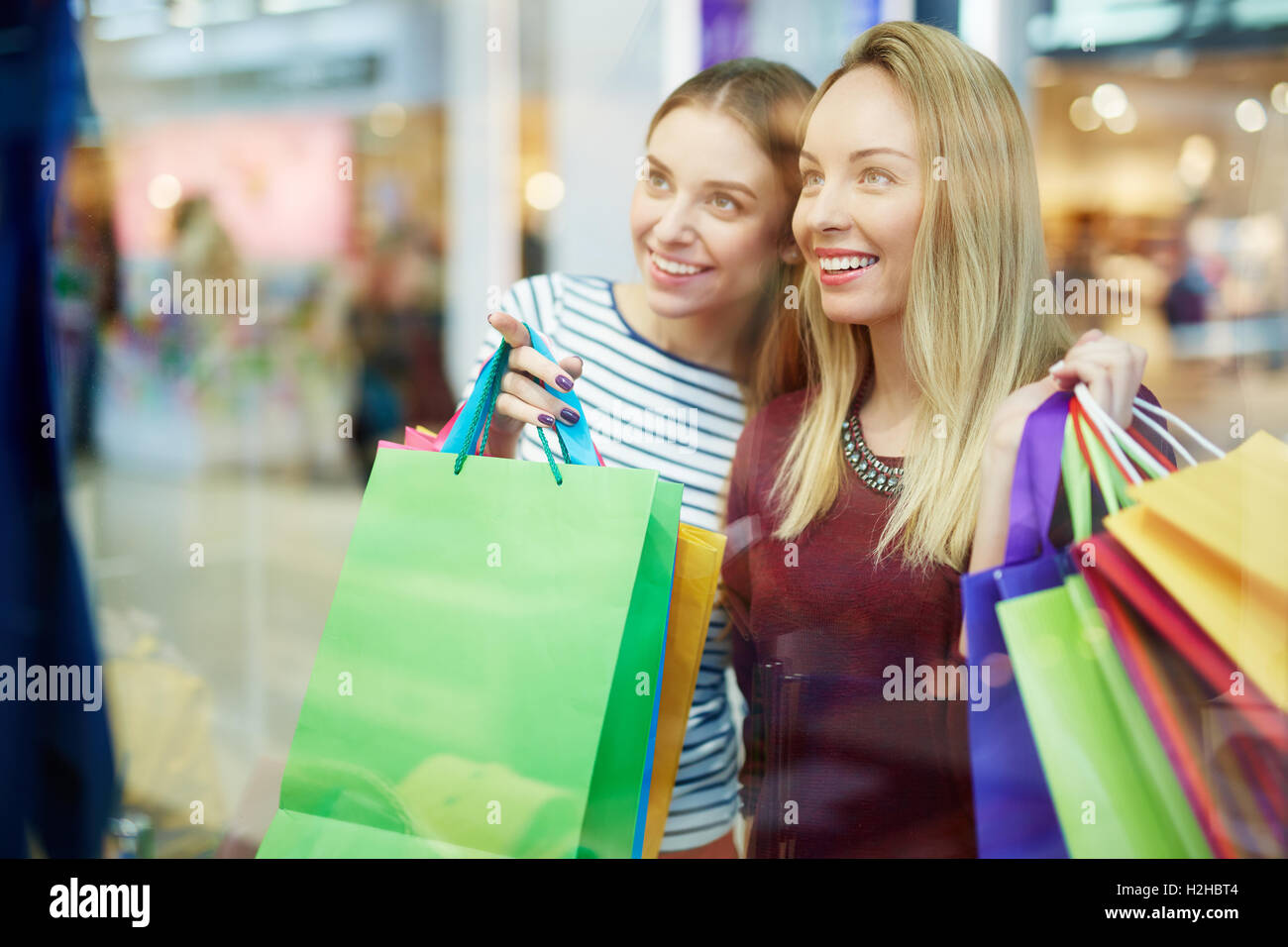 Happy shopper pointing at something in shop-window Stock Photo - Alamy