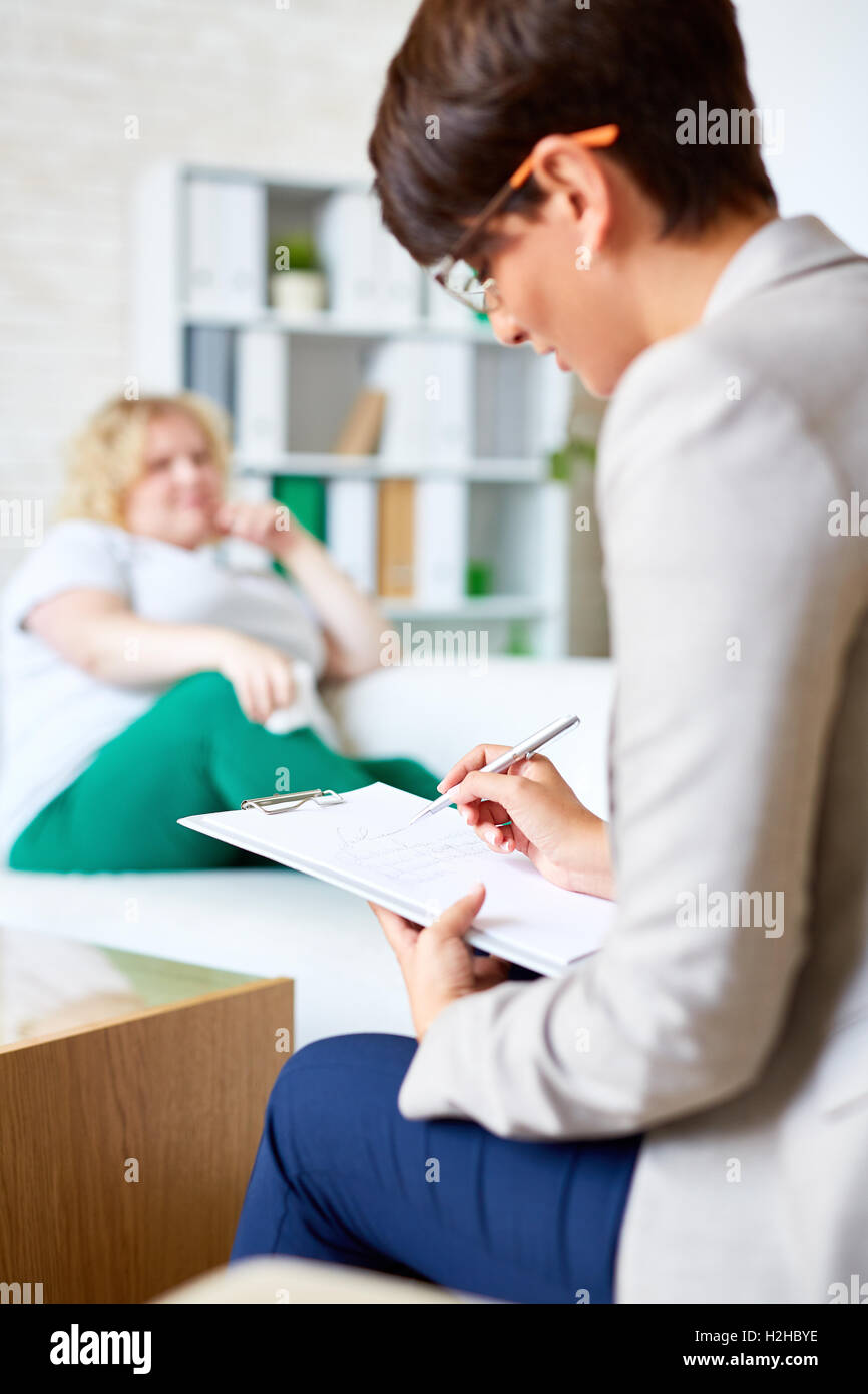 Female psychologist writing down her patient story Stock Photo - Alamy
