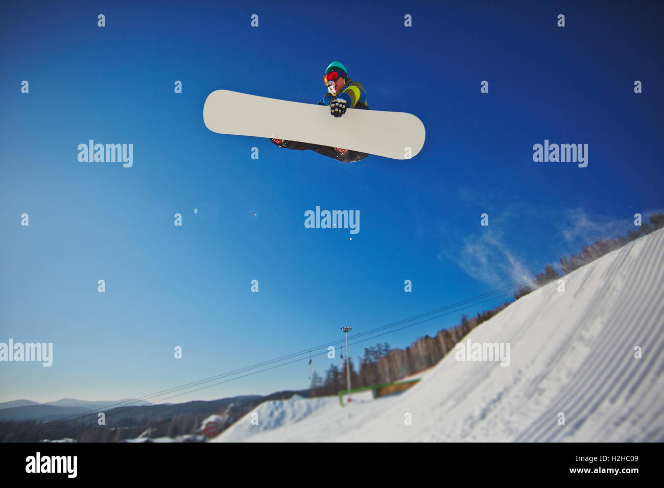 Freestyler on snowboard flying in jump at winter resort Stock Photo - Alamy