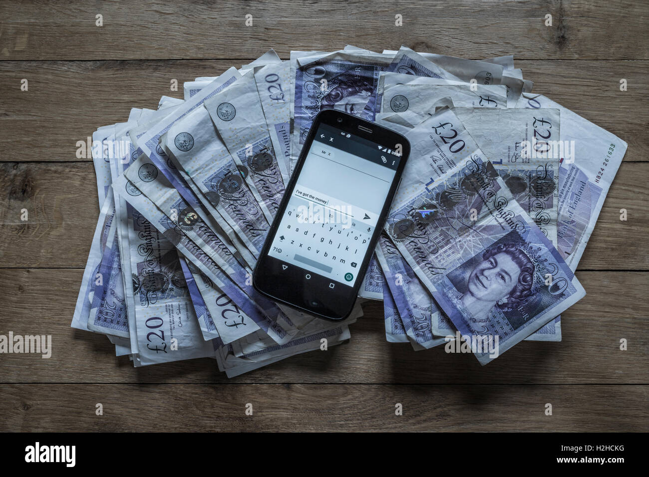 Pile of twenty pound notes and a mobile phone. Bribery concept Stock ...