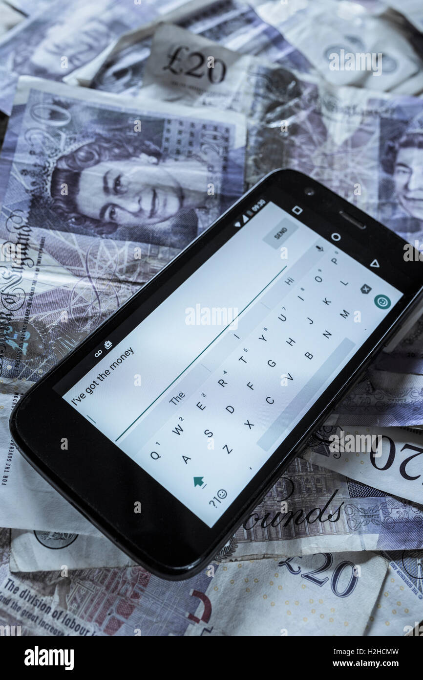 Pile of twenty pound notes and a mobile phone. Bribery concept Stock ...