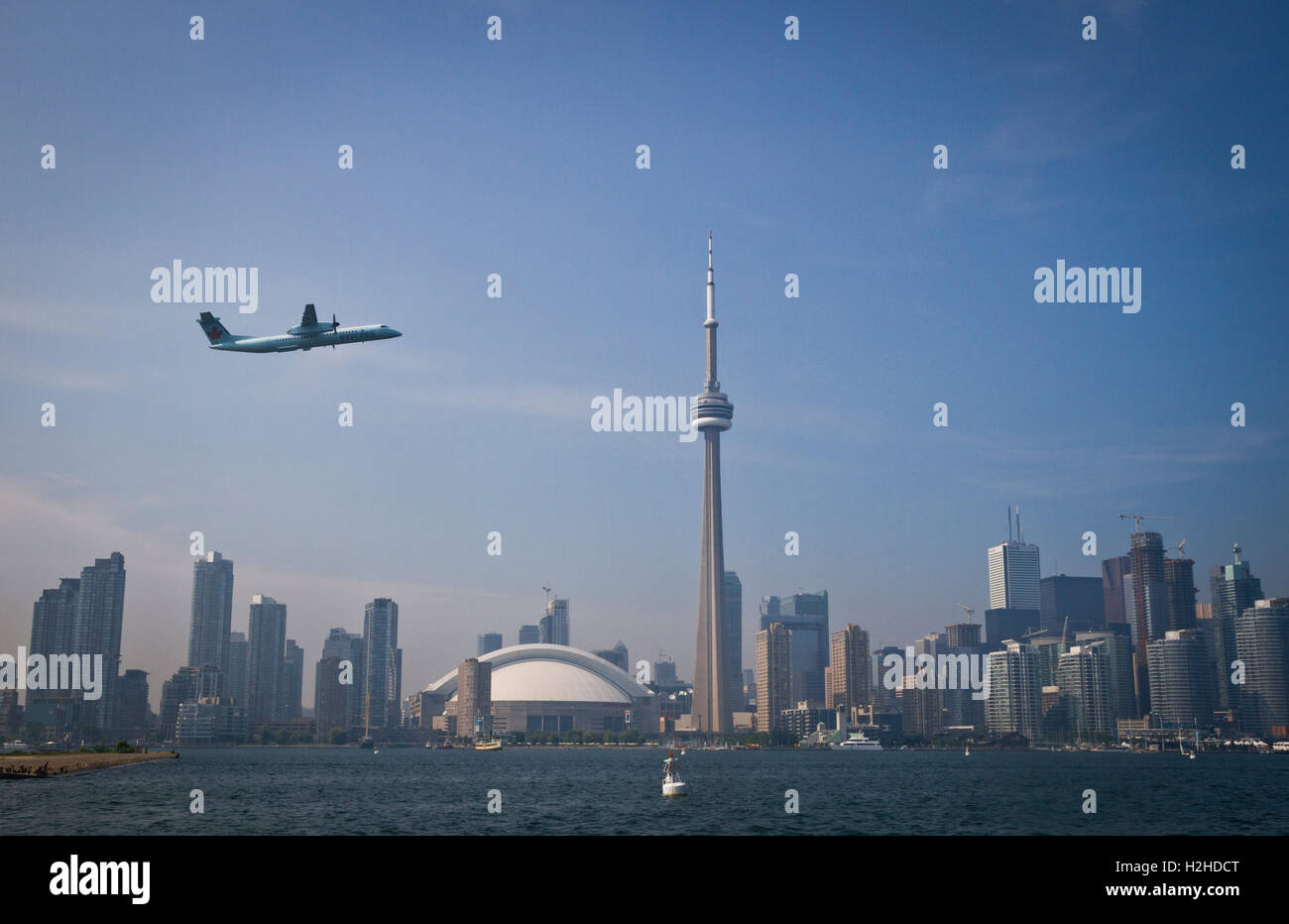 A plane takes off in front of a view of the CN Tower from the islands ...