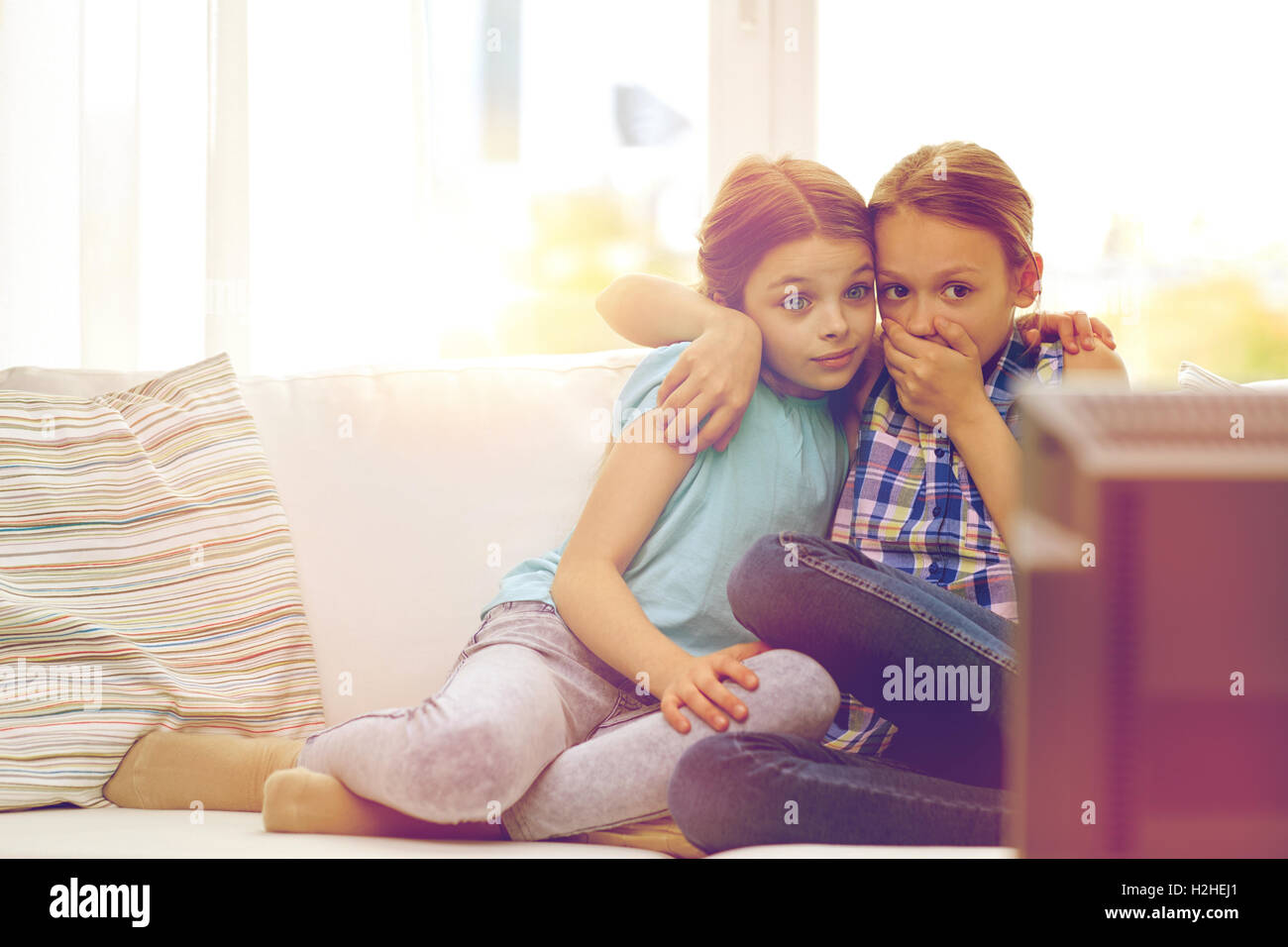scared little girls watching horror on tv at home Stock Photo - Alamy