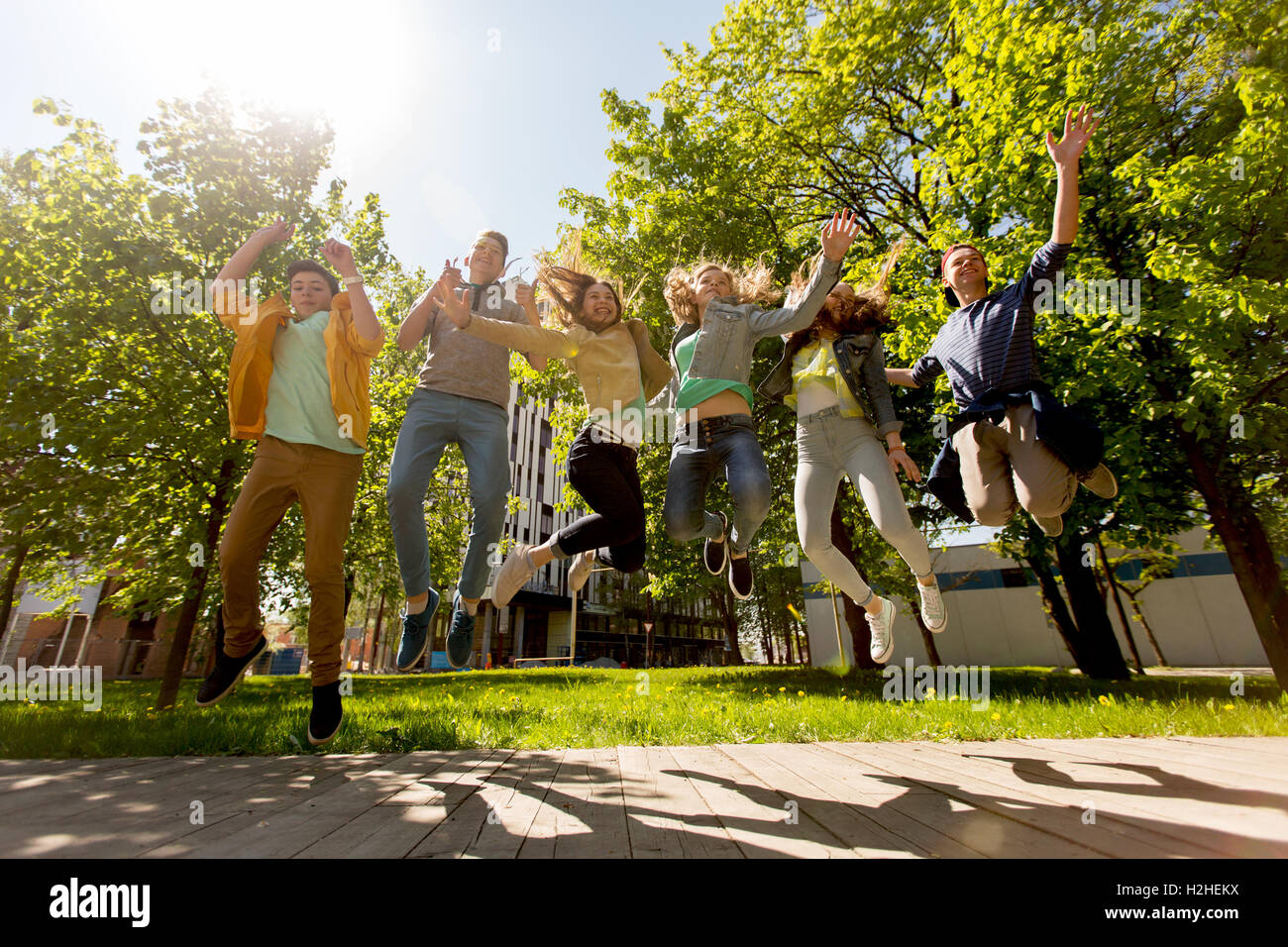 happy teenage students or friends jumping outdoors Stock Photo - Alamy