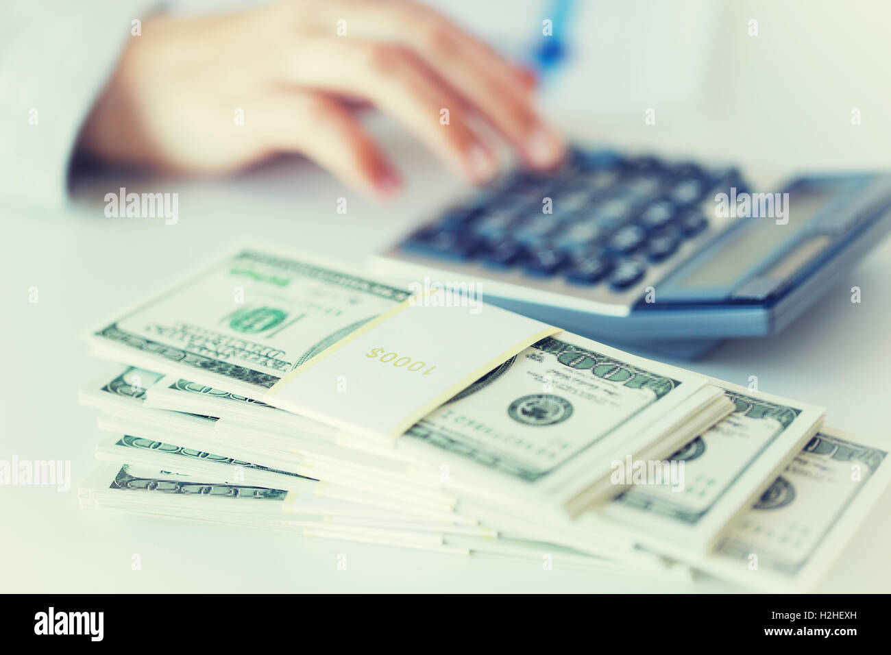 close up of hand counting money with calculator Stock Photo - Alamy