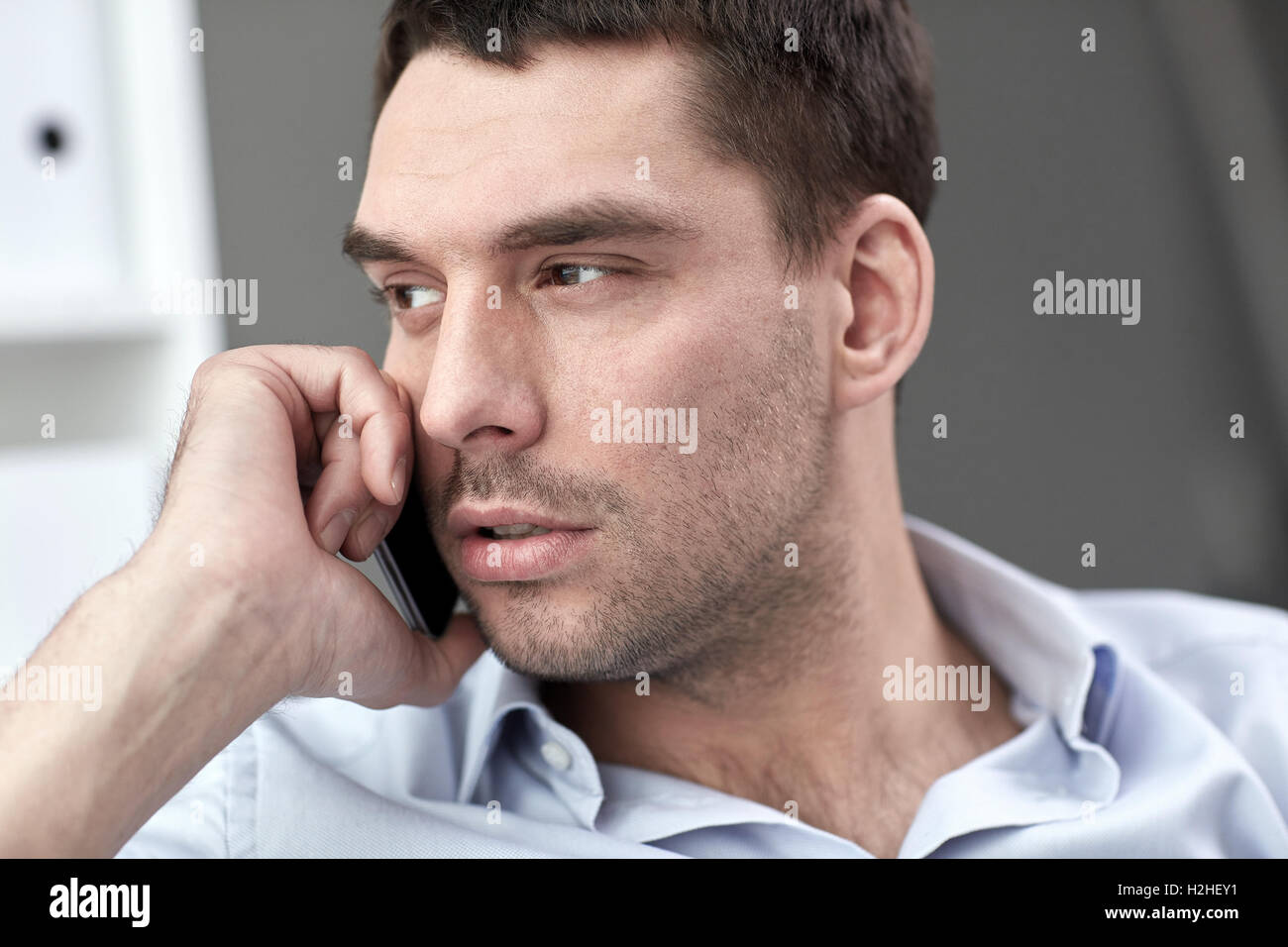face of young businessman calling on smartphone Stock Photo - Alamy