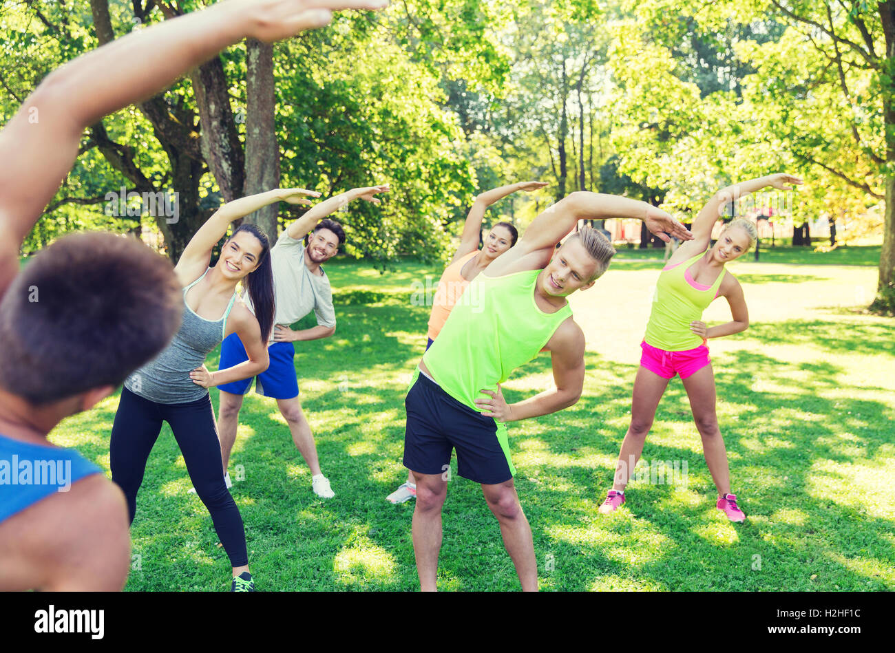 group of friends or sportsmen exercising outdoors Stock Photo - Alamy