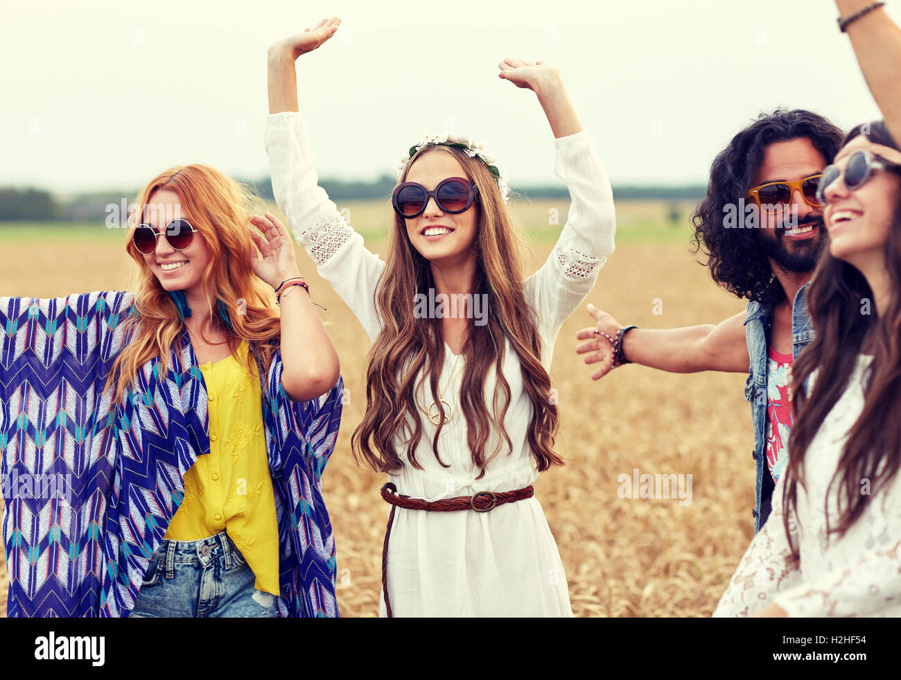 happy young hippie friends dancing on cereal field Stock Photo - Alamy