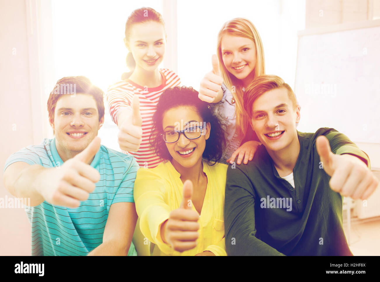 smiling students at school showing thumbs up Stock Photo - Alamy