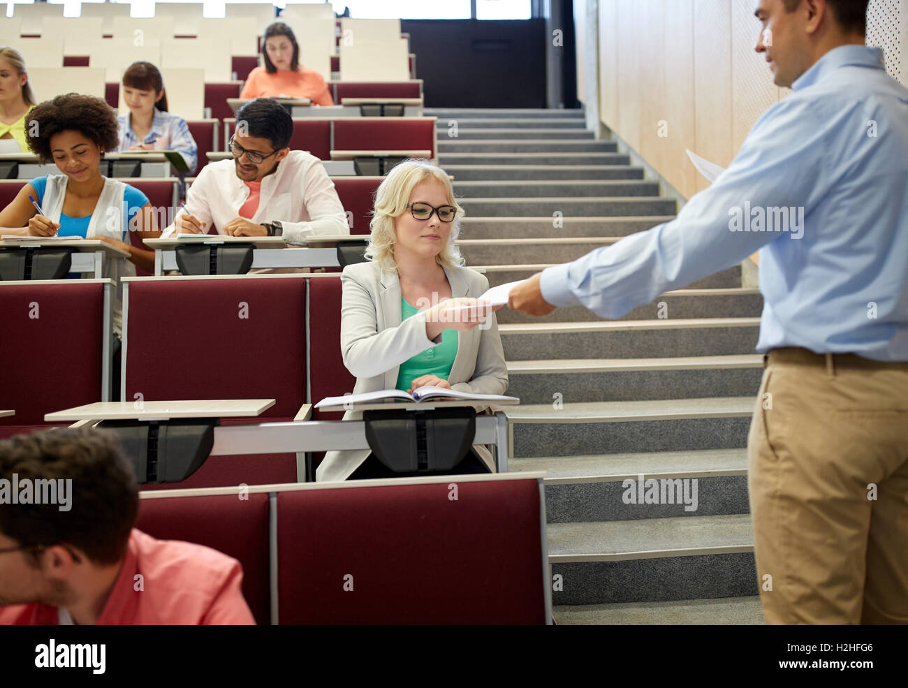 teacher giving exam tests to students at lecture Stock Photo - Alamy