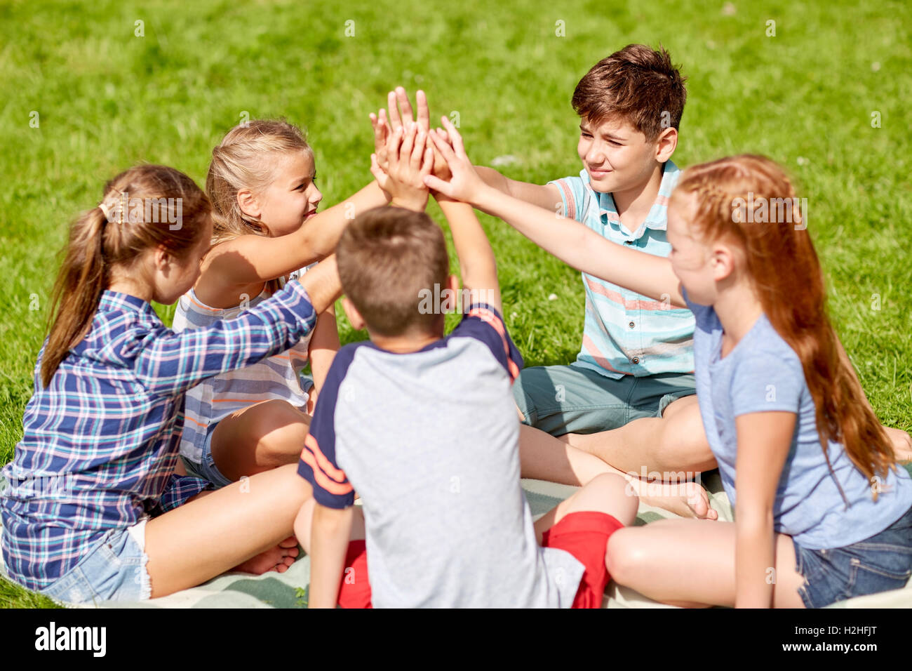 group of happy kids making high five outdoors Stock Photo - Alamy