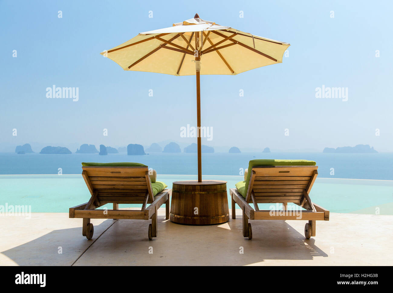 infinity pool with parasol and sun beds at seaside Stock Photo - Alamy
