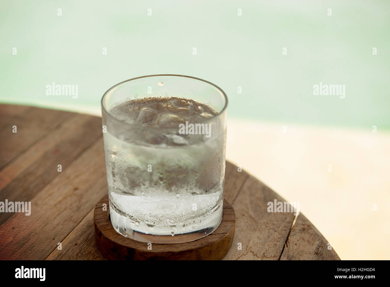 glass of water with ice cubes on table at beach Stock Photo - Alamy