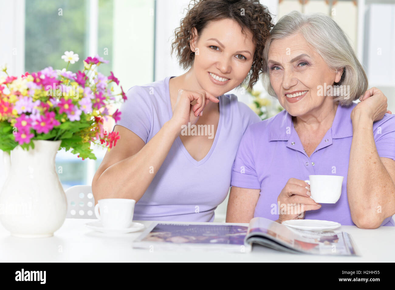 Senior woman with daughter with magazine Stock Photo - Alamy
