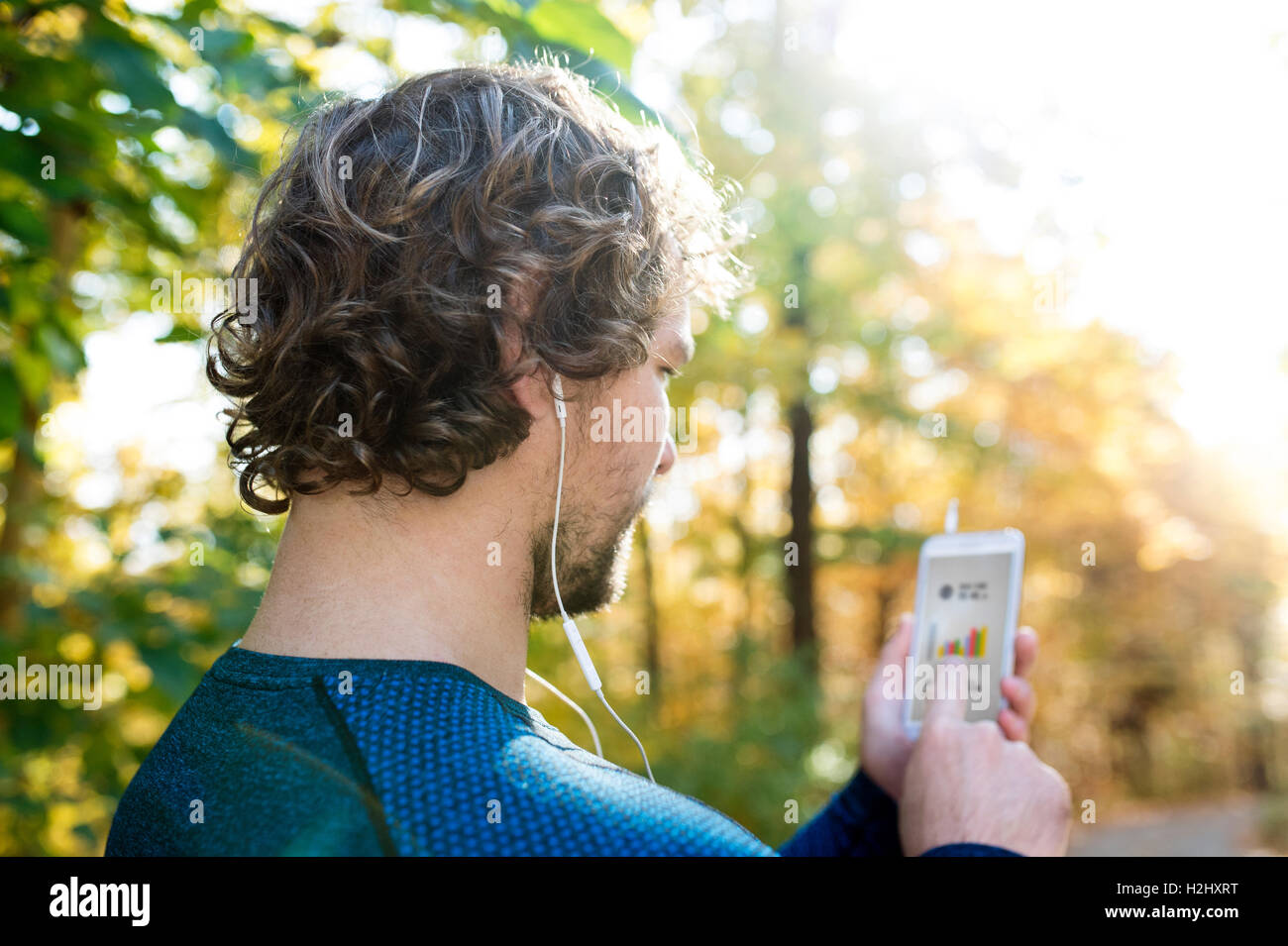 Man running with smart phones and earphones Stock Photo - Alamy