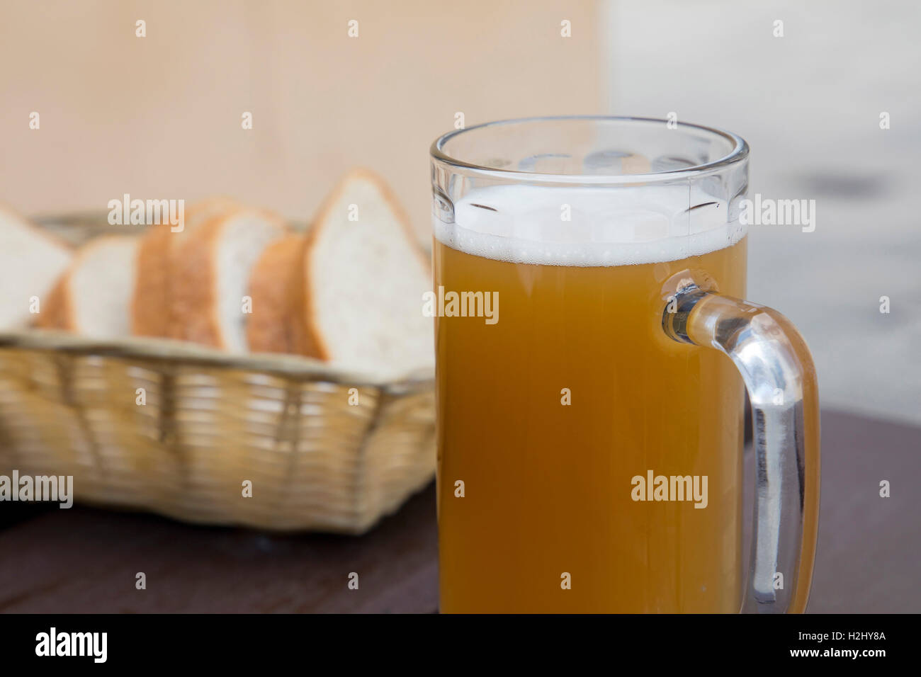 One glass of unfiltered craft draft wheat weizen beer and sliced bread ...