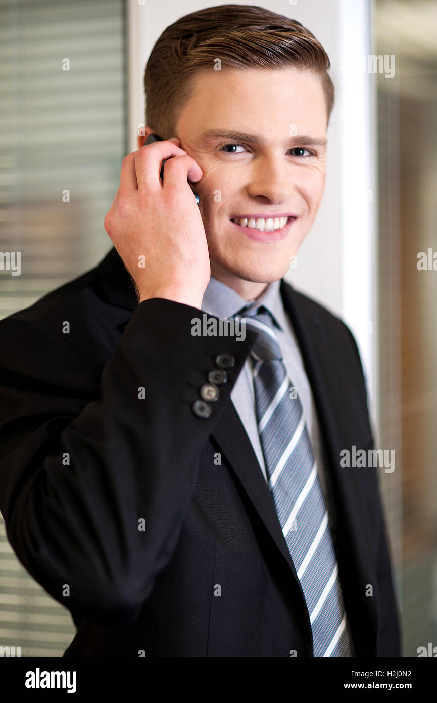 Smiling corporate guy attending phone call Stock Photo - Alamy