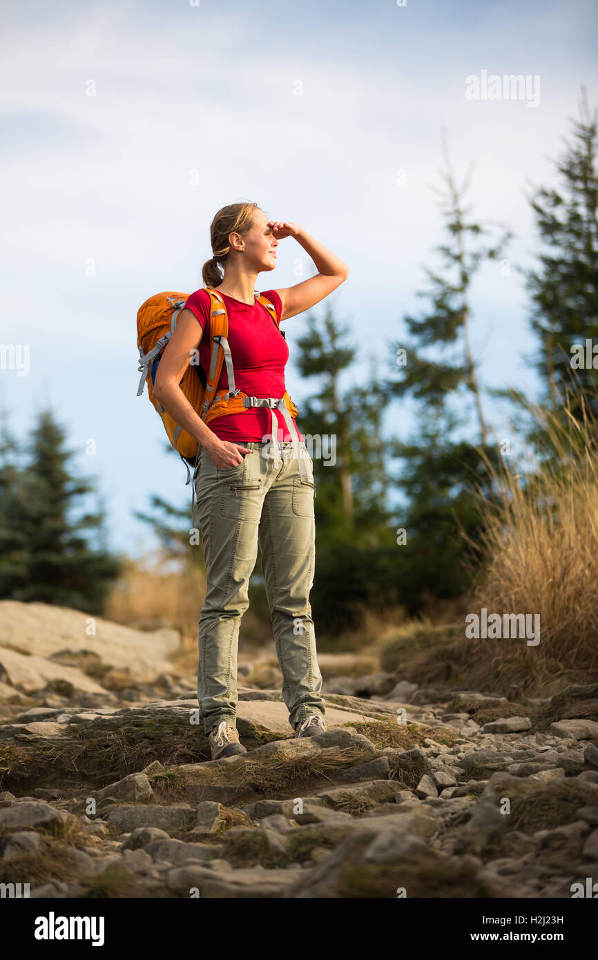 Pretty, female hiker going downhill in warm evening light Stock Photo ...