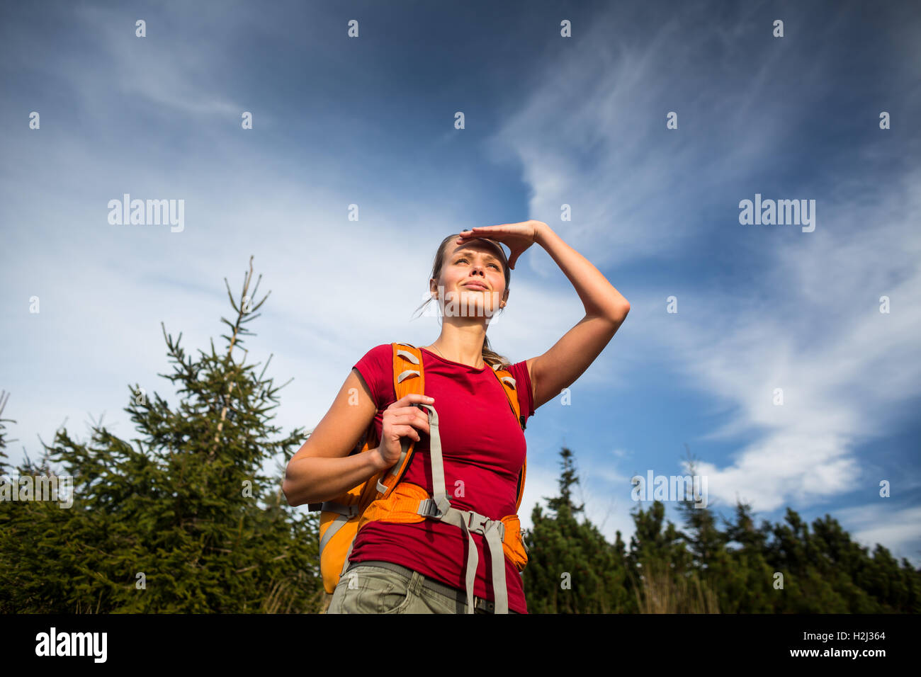 Pretty, female hiker going downhill in warm evening light Stock Photo ...