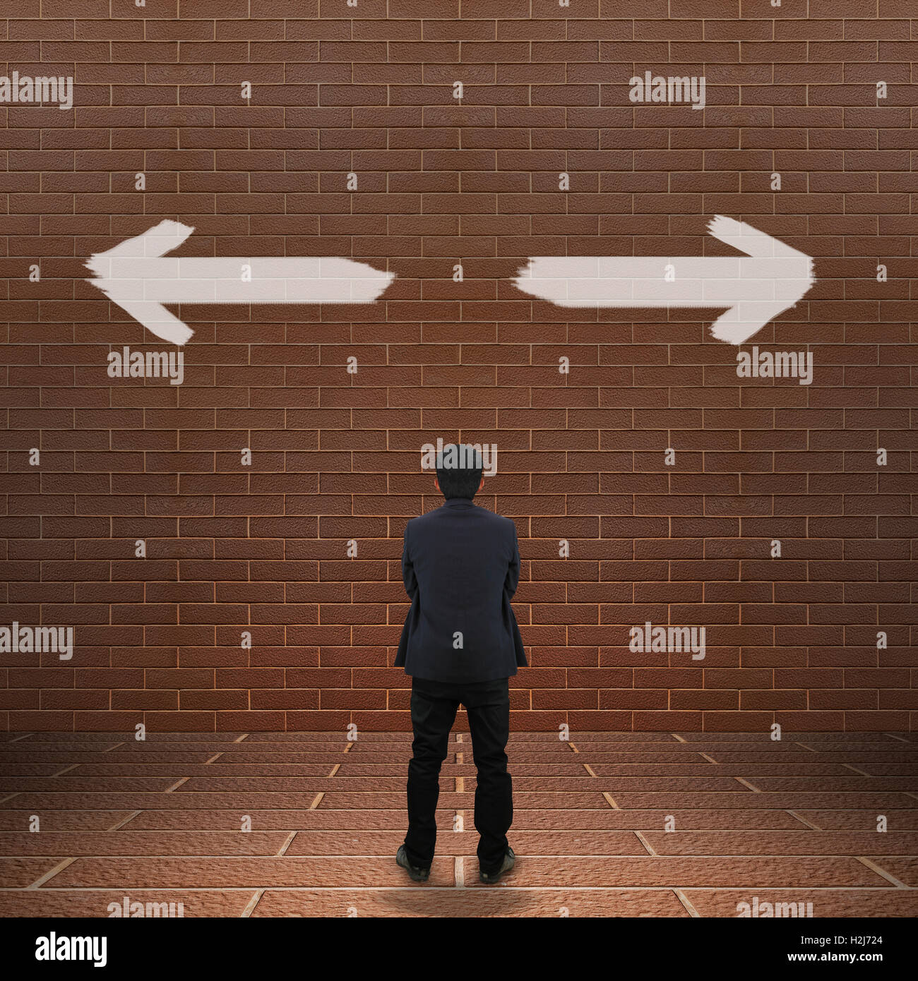 Businessman looking at arrows Stock Photo - Alamy