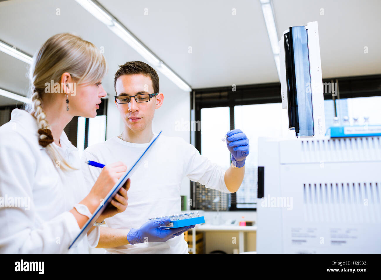 Two young researchers carrying out experiments in a lab Stock Photo - Alamy