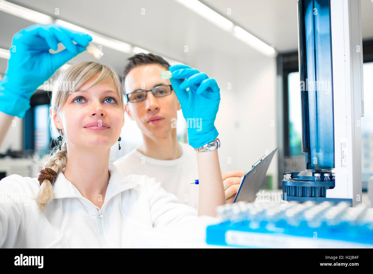 Two young researchers carrying out experiments in a lab Stock Photo - Alamy