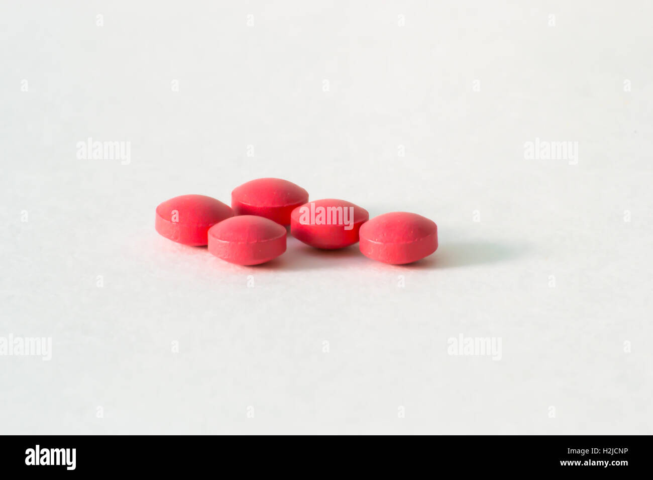 Five red pills on white background. Medicine Stock Photo - Alamy