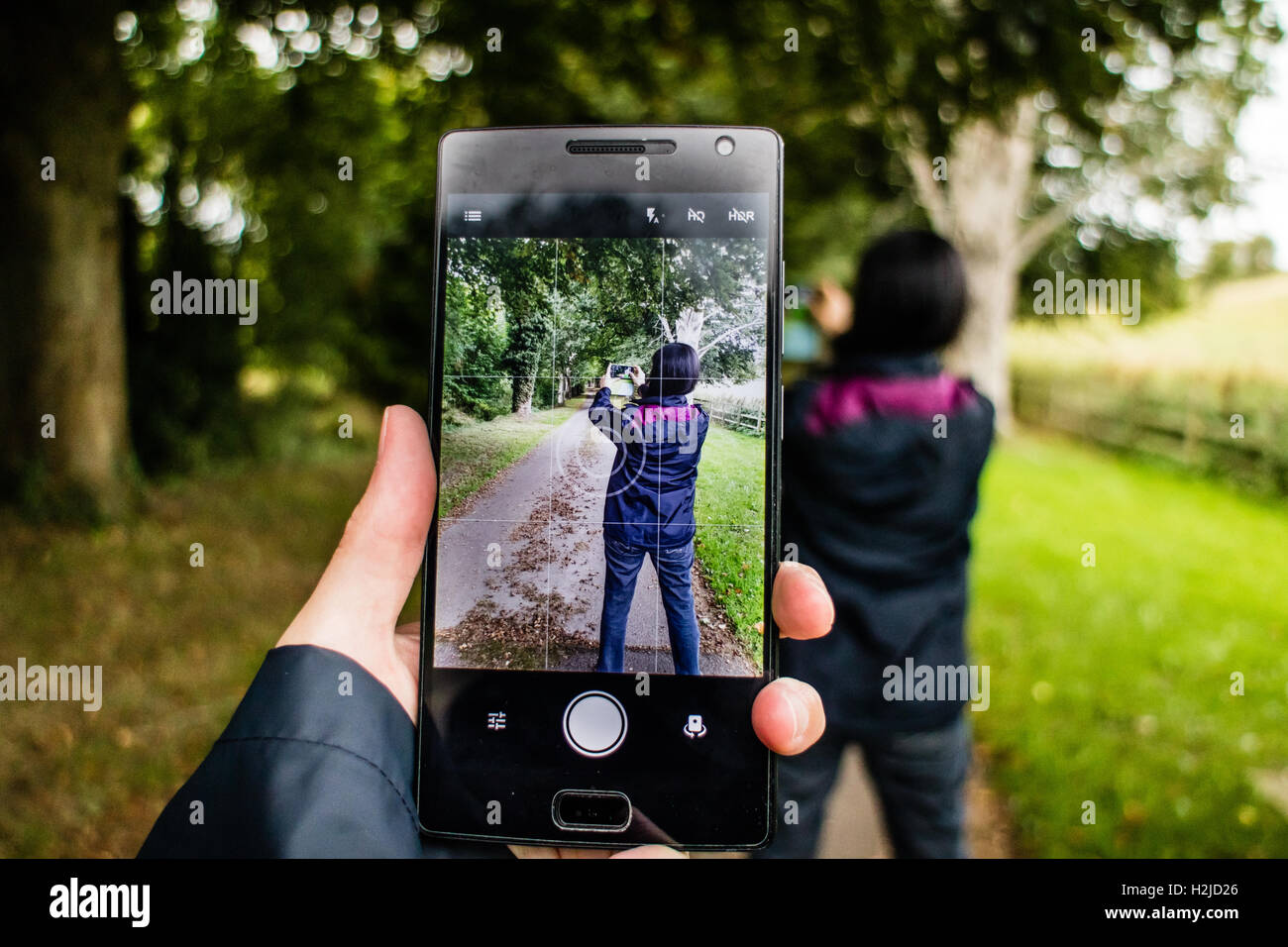 Taking a photo of an asian woman using mobile phone to capture a ...