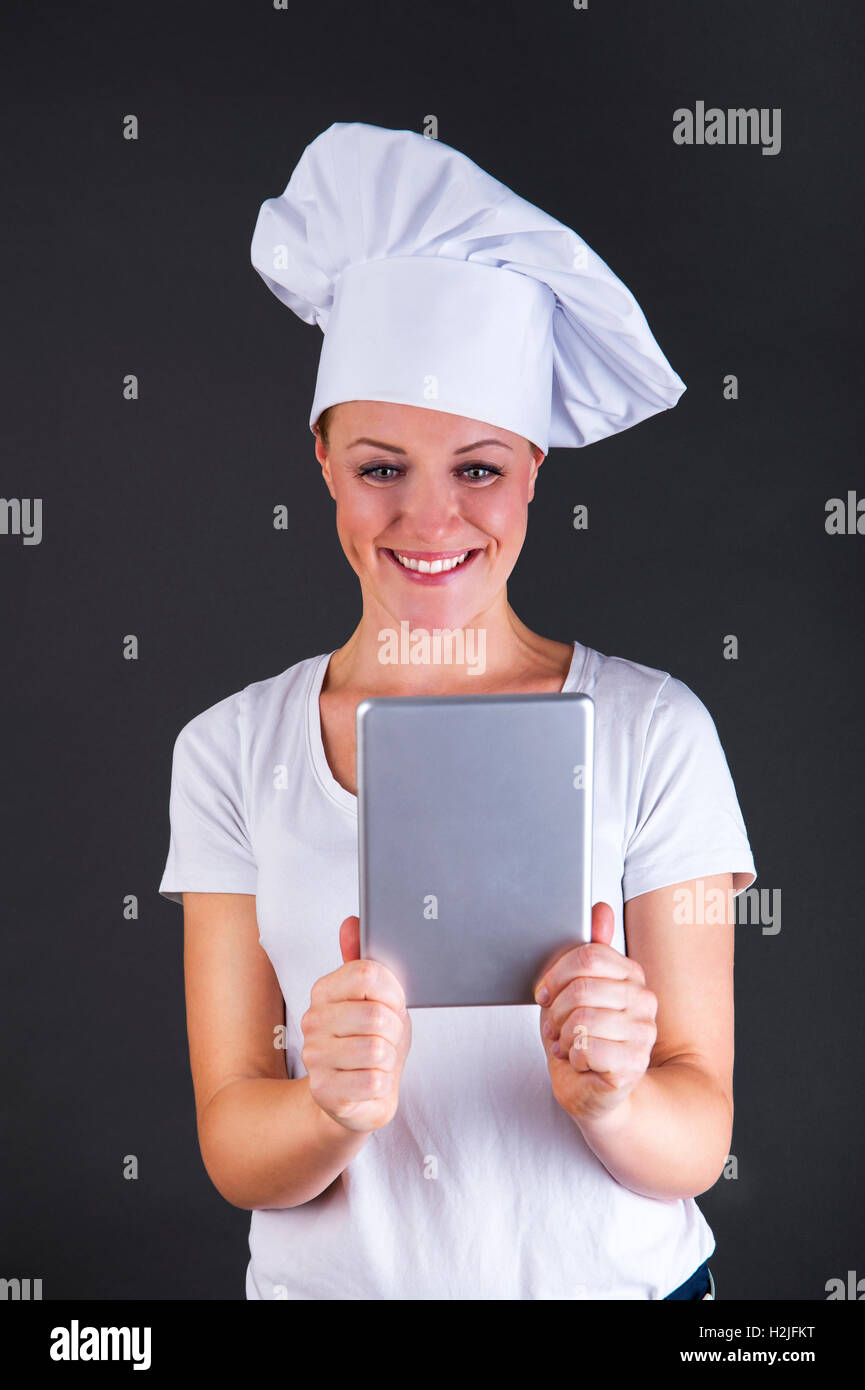 cooking, technology and food concept - smiling female chef, cook or ...