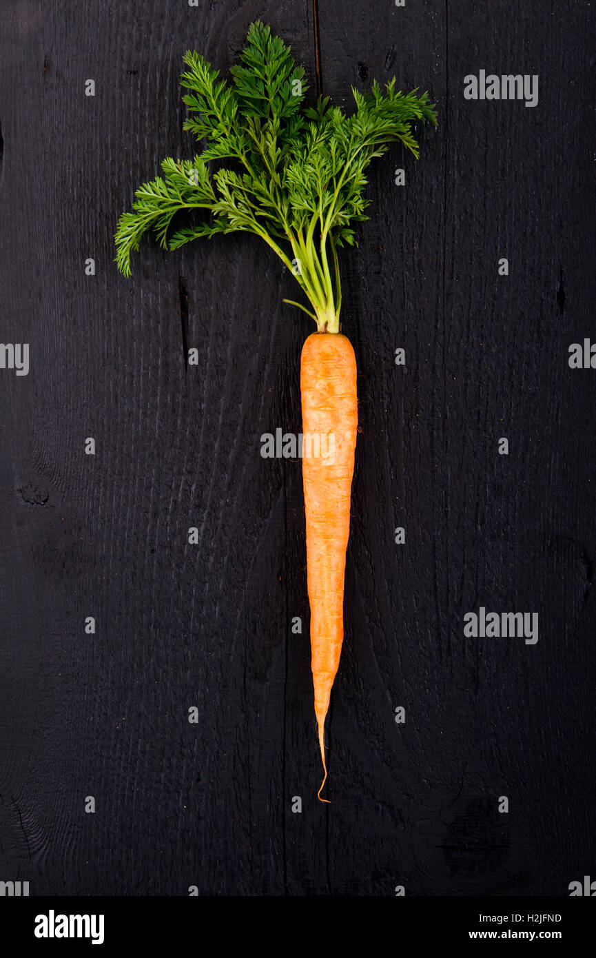 Carrot with green leaves over wooden background. Vegetable. Food Stock ...