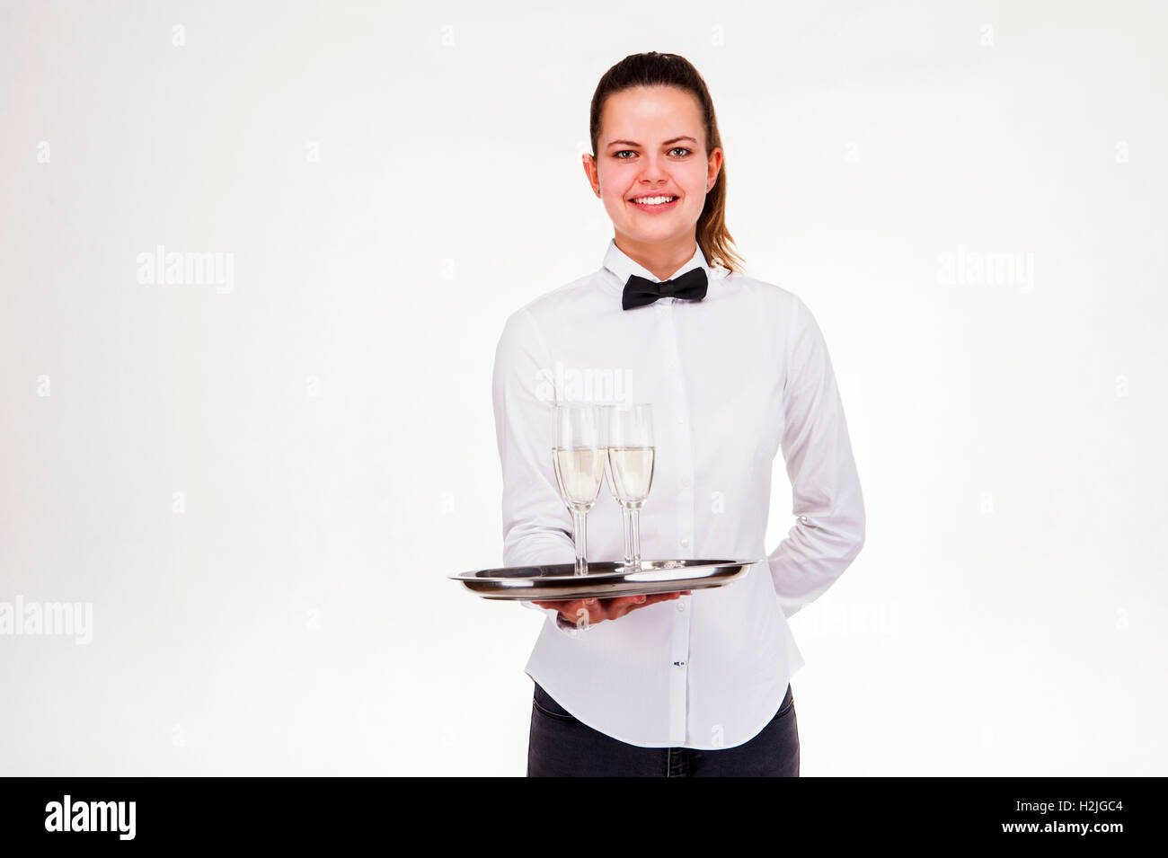 Woman in waiter uniform holding tray and glasses with champagne ...