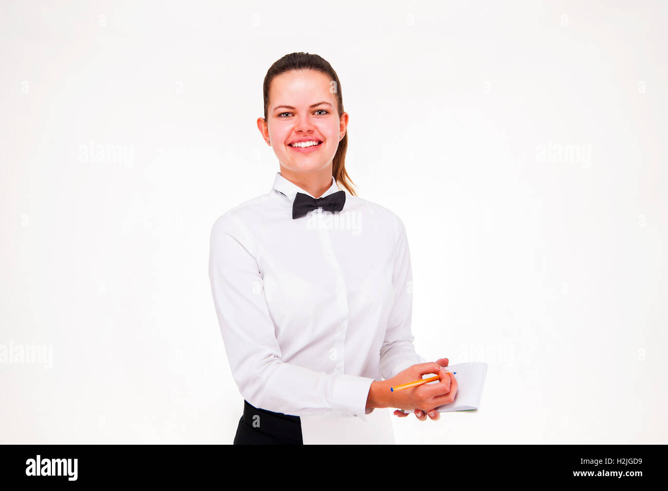 Young woman in waiter uniform holding notepad over white background ...